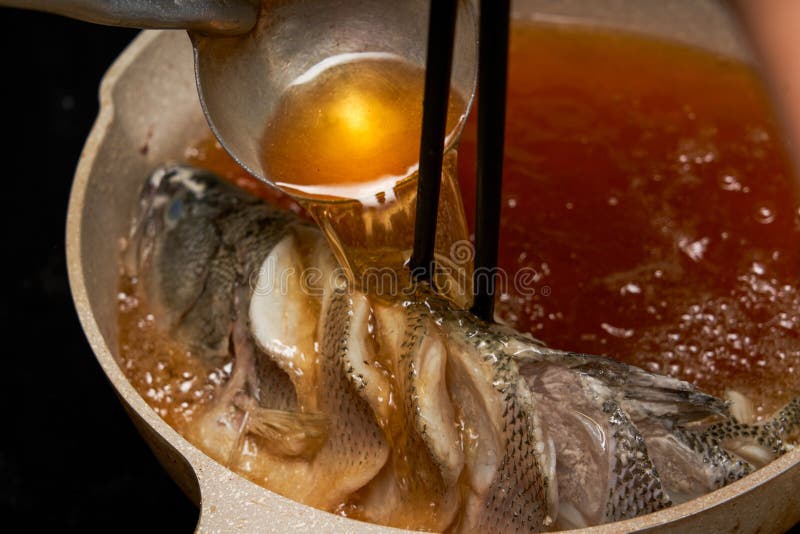 A Chef in the Kitchen is Making Fried Fish, Frying a Whole Fish Stock ...