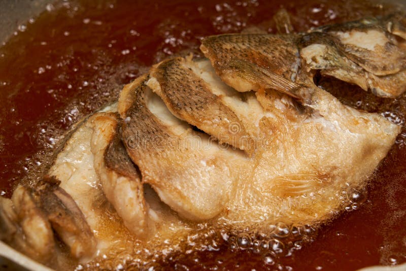 A Chef in the Kitchen is Making Fried Fish, Frying a Whole Fish Stock ...