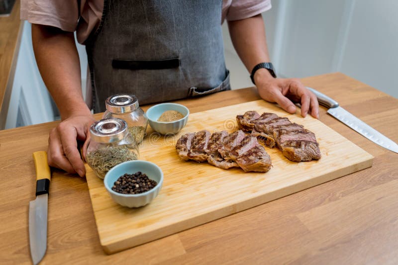 Chef at the Kitchen Preparing Beef Steaks on the Home Electric Grill ...