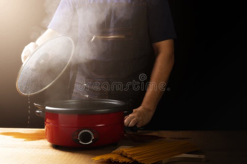 The Chef Makes Spaghetti in a Pot in the Kitchen, the Atmosphere is ...