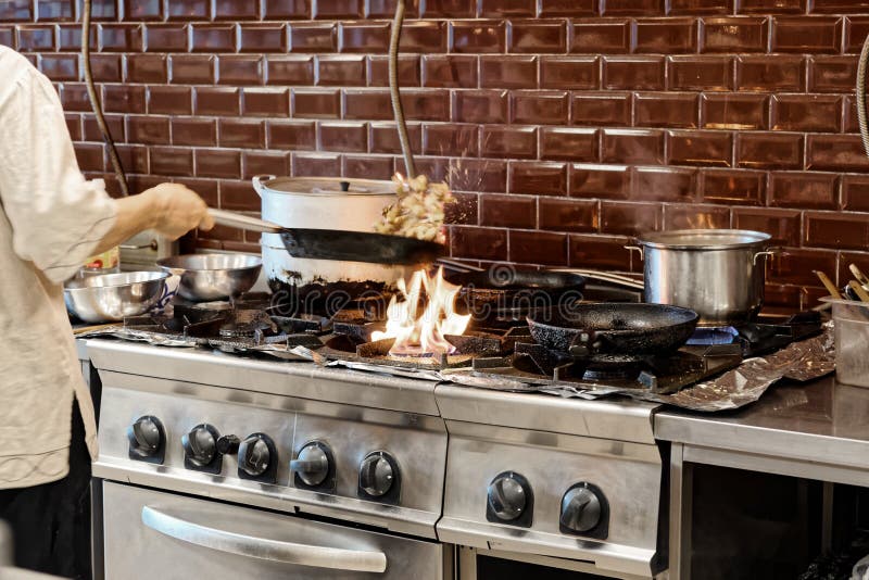 Chef is Making Flambe Dish in Restaurant Kitchen, Toned Stock Photo ...