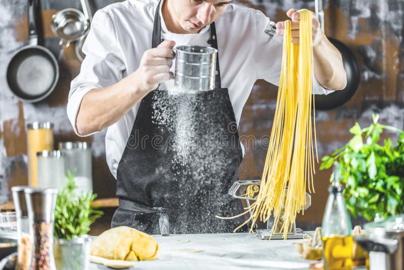 Chef Making Spaghetti Noodles with Pasta Machine on Kitchen Table with ...