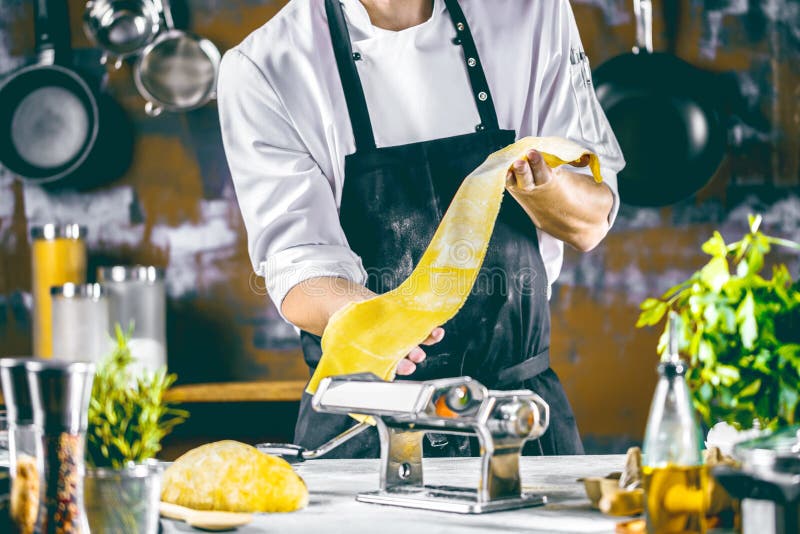 Chef Making Spaghetti Noodles with Pasta Machine on Kitchen Table with ...