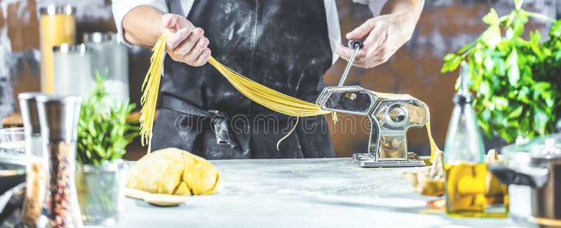 Chef Making Spaghetti Noodles with Pasta Machine on Kitchen Table with ...