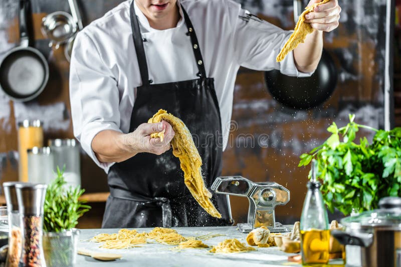 Chef Making Spaghetti Noodles with Pasta Machine on Kitchen Table with ...