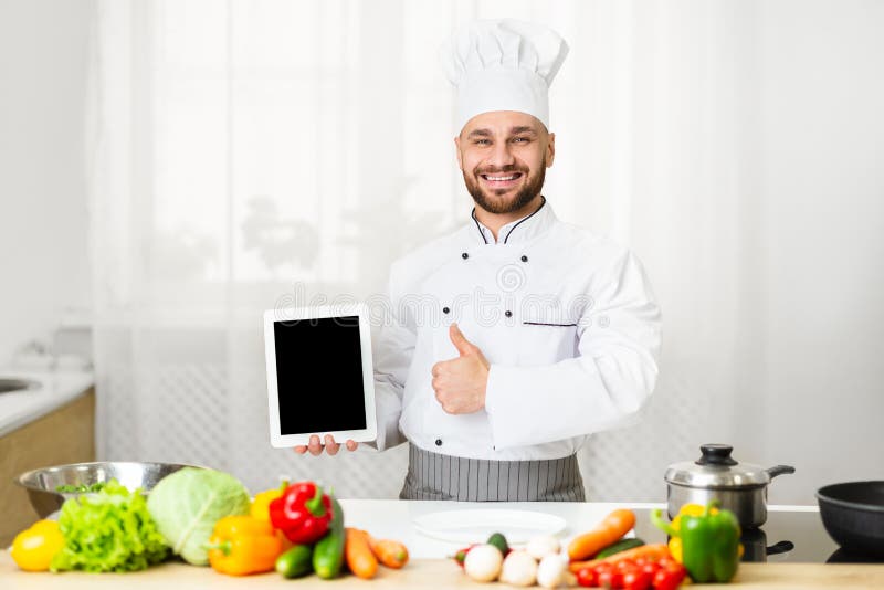 Chef Man Showing Tablet Screen Gesturing Thumbs-Up Standing in Kitchen ...