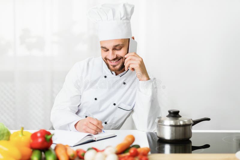 Chef Man Talking on Phone Taking Notes Standing in Kitchen Stock Image ...