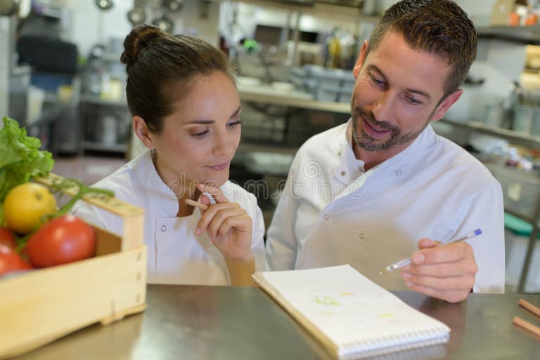 Chef Man and Woman Looking at Notes Stock Image - Image of beautiful ...
