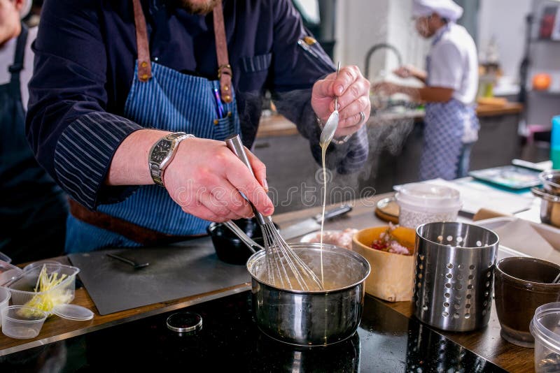 The Chef Mixes the Sauce in a Saucepan Using the Whisk. Master Class in ...