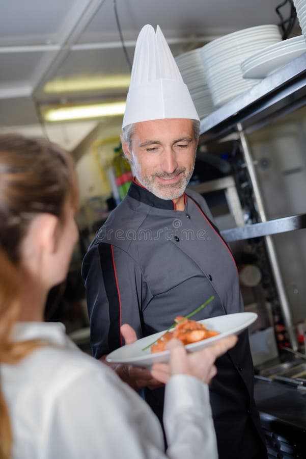 Chef Passing Dish To Waitress Stock Image - Image of kitchen, female ...