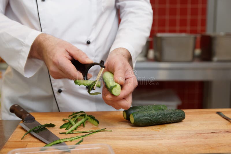 Chef is peeling cucumbers stock photo. Image of knife - 88039588