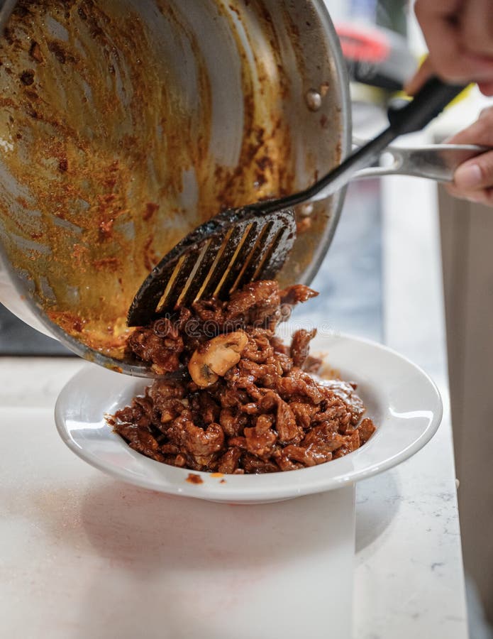 Chef Pouring Fried Beef with Mushroom from a Pan on Dish Stock Image ...