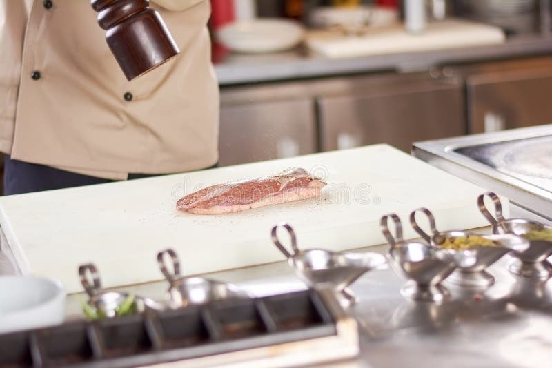 Chef Processing Raw Meat with Ground Pepper. Stock Image - Image of ...