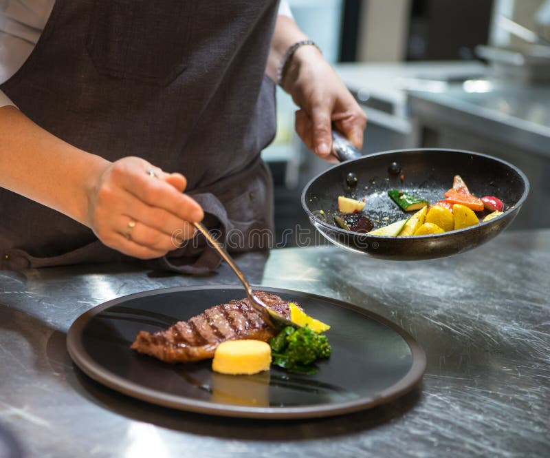 Chef Puts the Dish on a Plate. Preparing To Serve. Stock Photo - Image ...