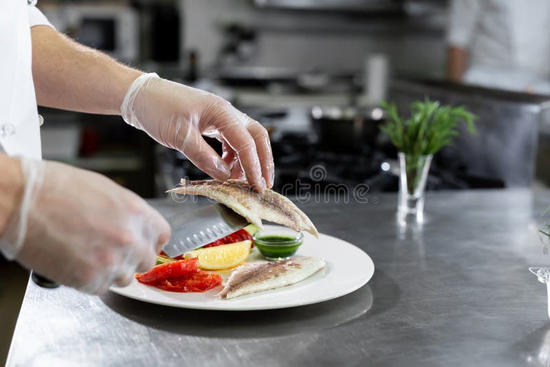 Chef Puts the Fish on a Plate. Stock Photo - Image of fish, garnishing ...