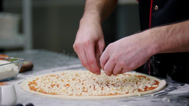 A Chef Putting Cheese on the Pizza. Aligning the Cheese Layer on the ...