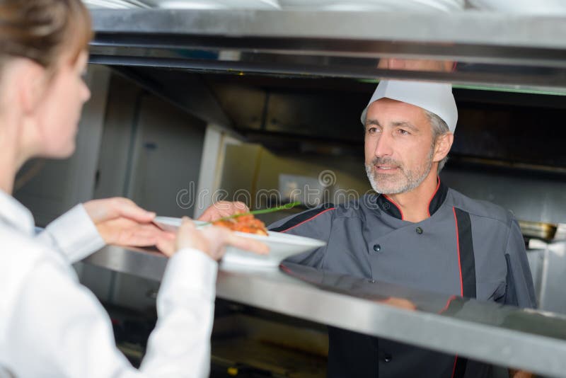 Chef Putting Plate on Serving Hatch Stock Image - Image of people ...