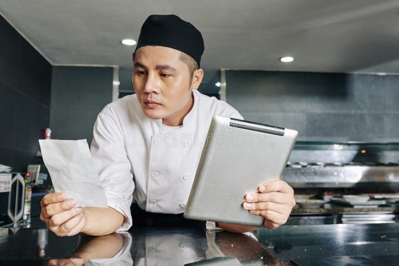 Chef reading a recipe stock image. Image of cafe, uniform - 158742407