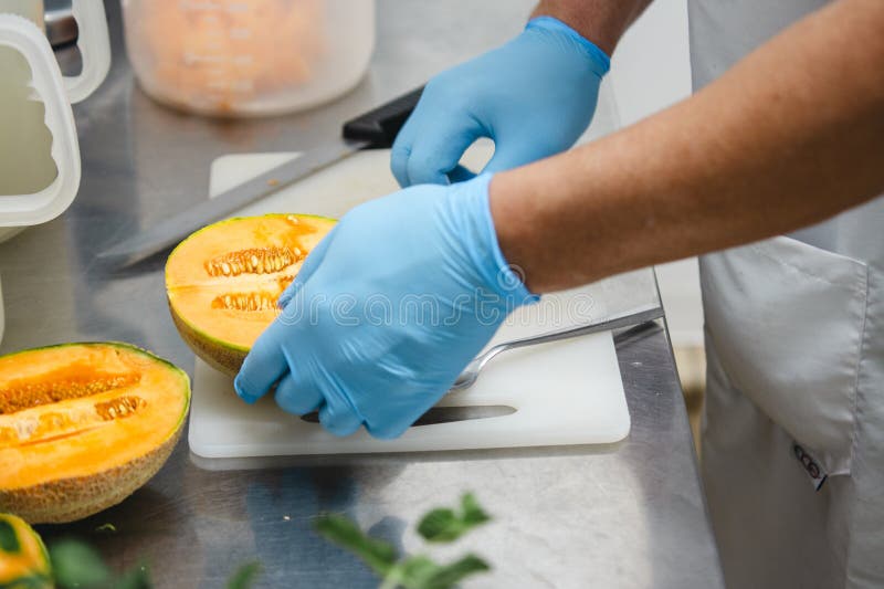 Chef Removing Seeds from Melon Using a Spoon Wearing Blue Gloves Stock ...