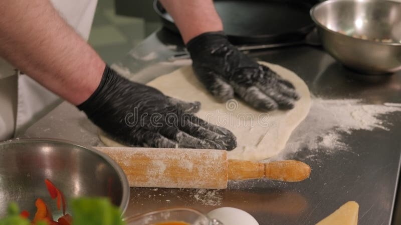 A Chef Rolling Out Pizza Dough with a Rolling Pin in the Restaurant ...