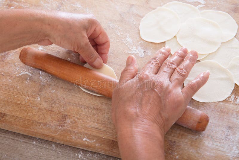 The Chef Rolls the Dumpling Wrapper on the Cutting Board with a Rolling ...