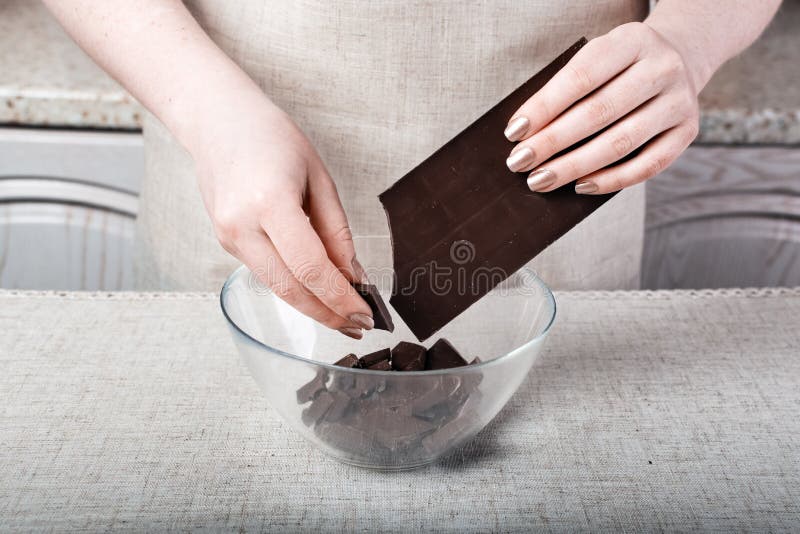 The Chef`s Hands Break a Bar of Chocolate into Small Pieces in a Glass ...