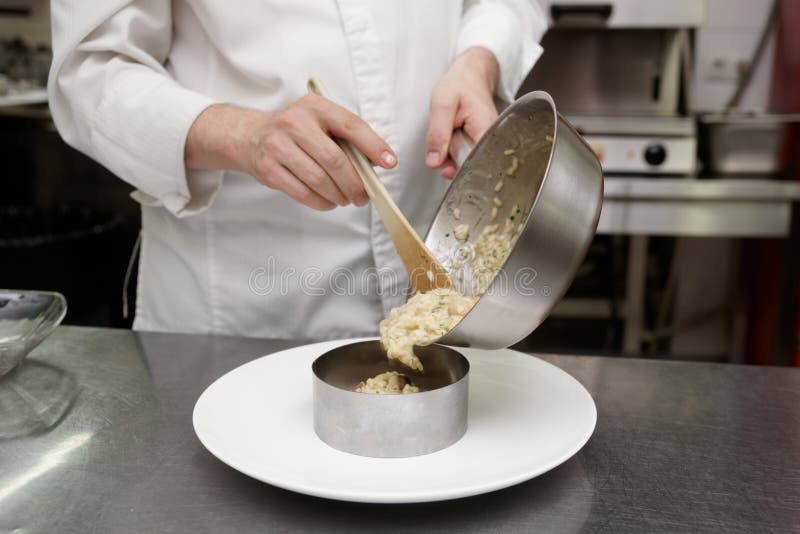 Chef is serving risotto stock photo. Image of decorating - 79339568