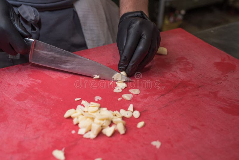 The Chef Slices the Garlic. Cooking in a Restaurant. Stock Photo ...