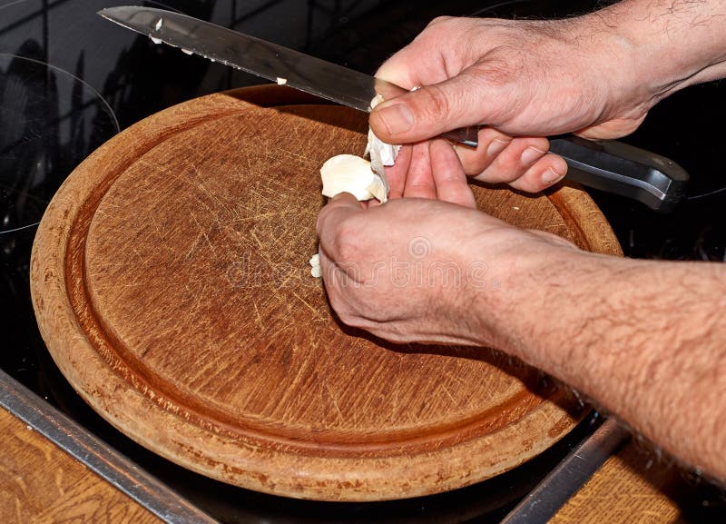 Chef Slicing Garlic Allium Sativum on the Cutting Board with a Knife ...