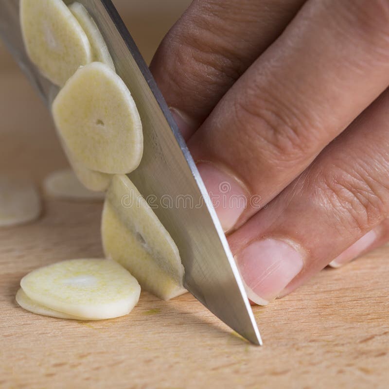 Chef slicing garlic cloves stock photo. Image of chopping - 44157446