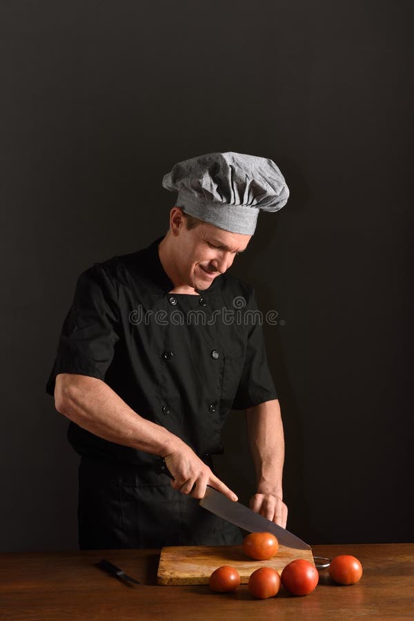 Chef slicing tomato stock image. Image of black, isolated - 176077219