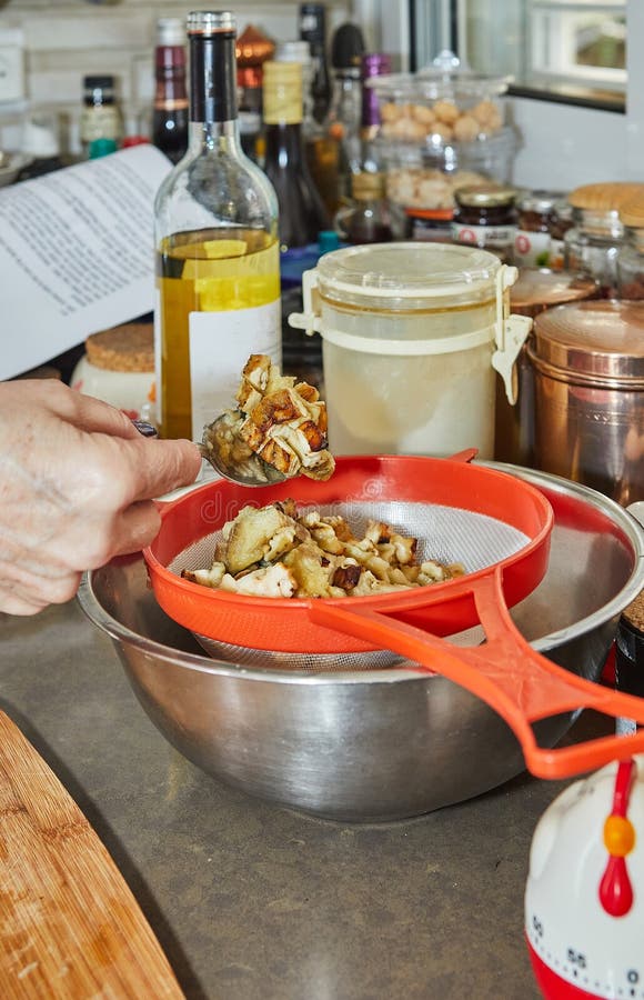 Chef Spoons the Pulp from an Oven-roasted Eggplant into Sieve Stock ...