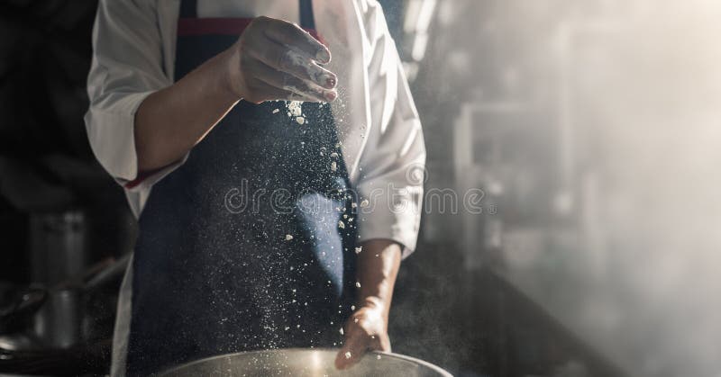 Chef sprinkles the flour stock photo. Image of chef - 219394970