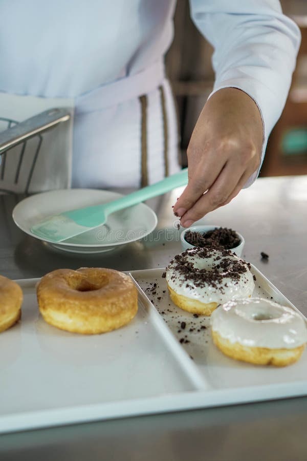 Chef sprinkling donuts stock photo. Image of food, chocolate - 144325418