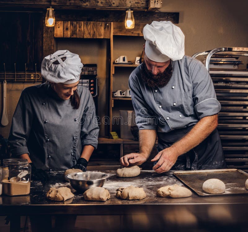 Chef Teaching His Assistant To Bake the Bread in a Bakery. Stock Image ...