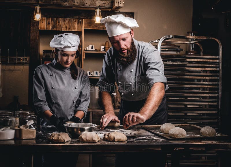 Chef Teaching His Assistant To Bake the Bread in a Bakery. Stock Photo ...