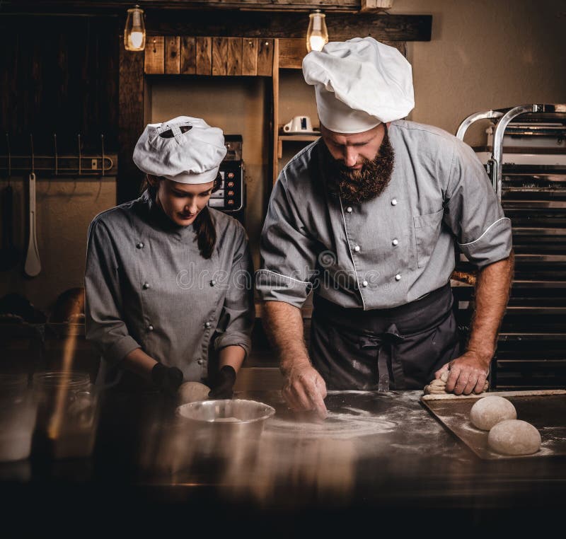 Chef Teaching His Assistant To Bake the Bread in a Bakery. Stock Image ...