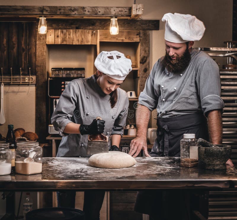 Chef Teaching His Assistant To Bake the Bread in a Bakery. Stock Photo ...