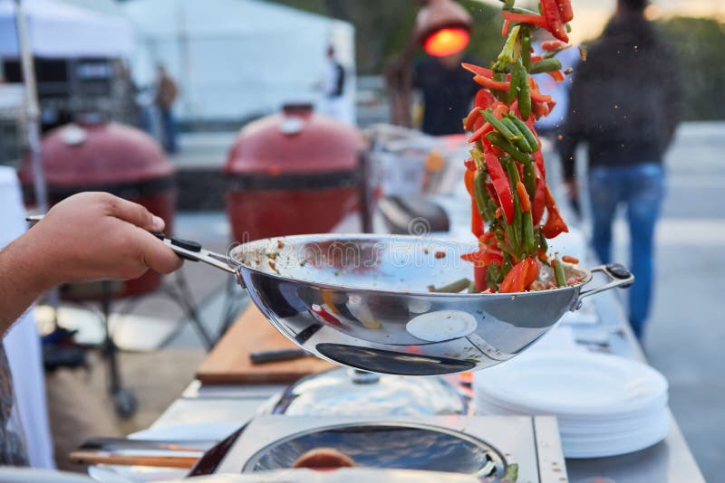 Chef Tossing Vegetables in a Wok in an Outdoor Kitchen. Stock Photo ...
