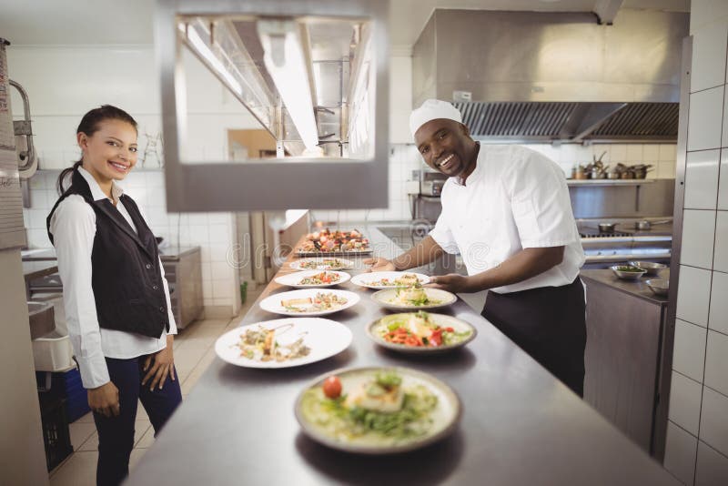 Chef and Waitress Showing Food Dishes To the Camera Stock Image - Image ...