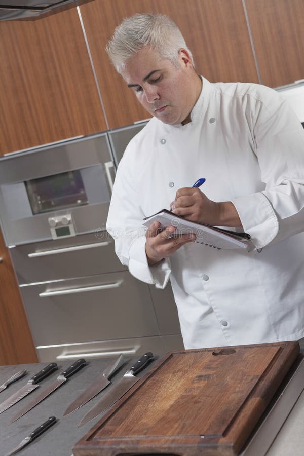 Chef Writing on Notepad in Commercial Kitchen Stock Image - Image of ...