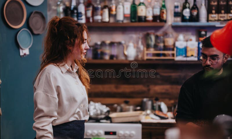 Chefs Collaborating in a Warmly Lit Bar Kitchen with Drinks Selection ...
