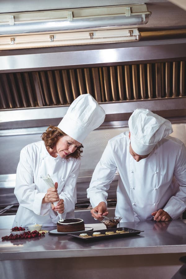 Chefs decorating a cake stock photo. Image of culinary - 68241566