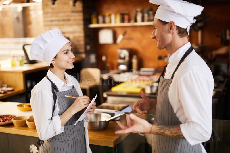 Two chefs discussing menu stock photo. Image of cheerful - 158740872