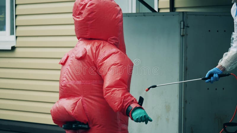 Chemical Disinfectant is Getting Sprayed on a Worker in a Red Suit ...