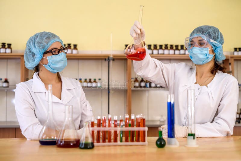 Chemical Experiment in Laboratory. Two Chemists Examining Flask with ...