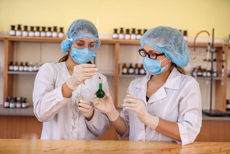Chemical Experiment.Two Women in Protective Uniform with Test Tubes in ...