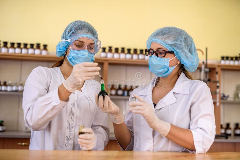 Chemical Experiment.Two Women in Protective Uniform with Test Tubes in ...