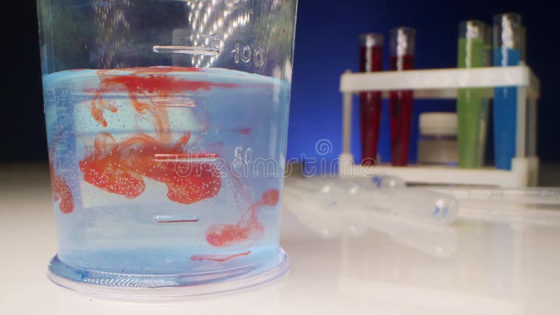 Chemical Experiments. Red Liquid Dissolves in a Clear Liquid in a Test ...