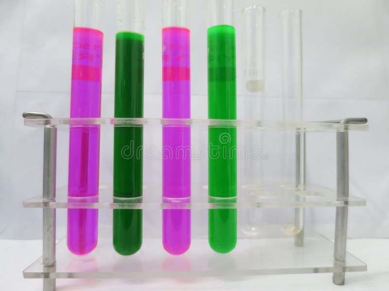 Four Test Tubes with Red, Yellow and Blue Liquid on a White Background ...
